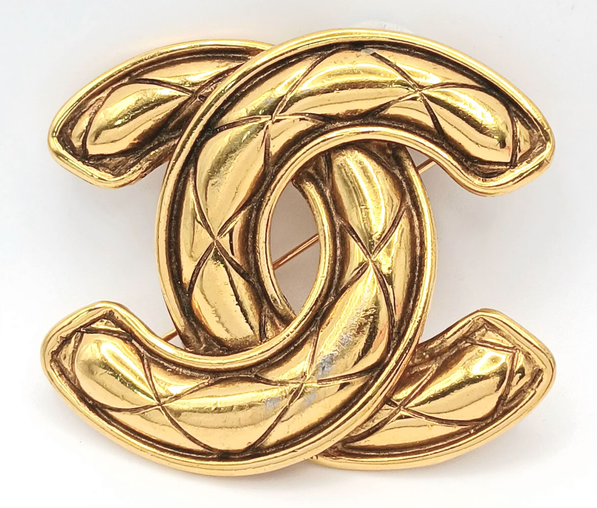 Une broche de mode Chanel de couleur dorée. En bo... | Bijoux: enchères