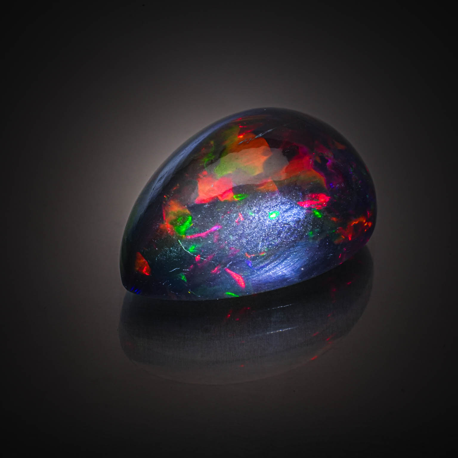 Black pear-shaped cabochon opal on pape... | Semi-precious stones: bids