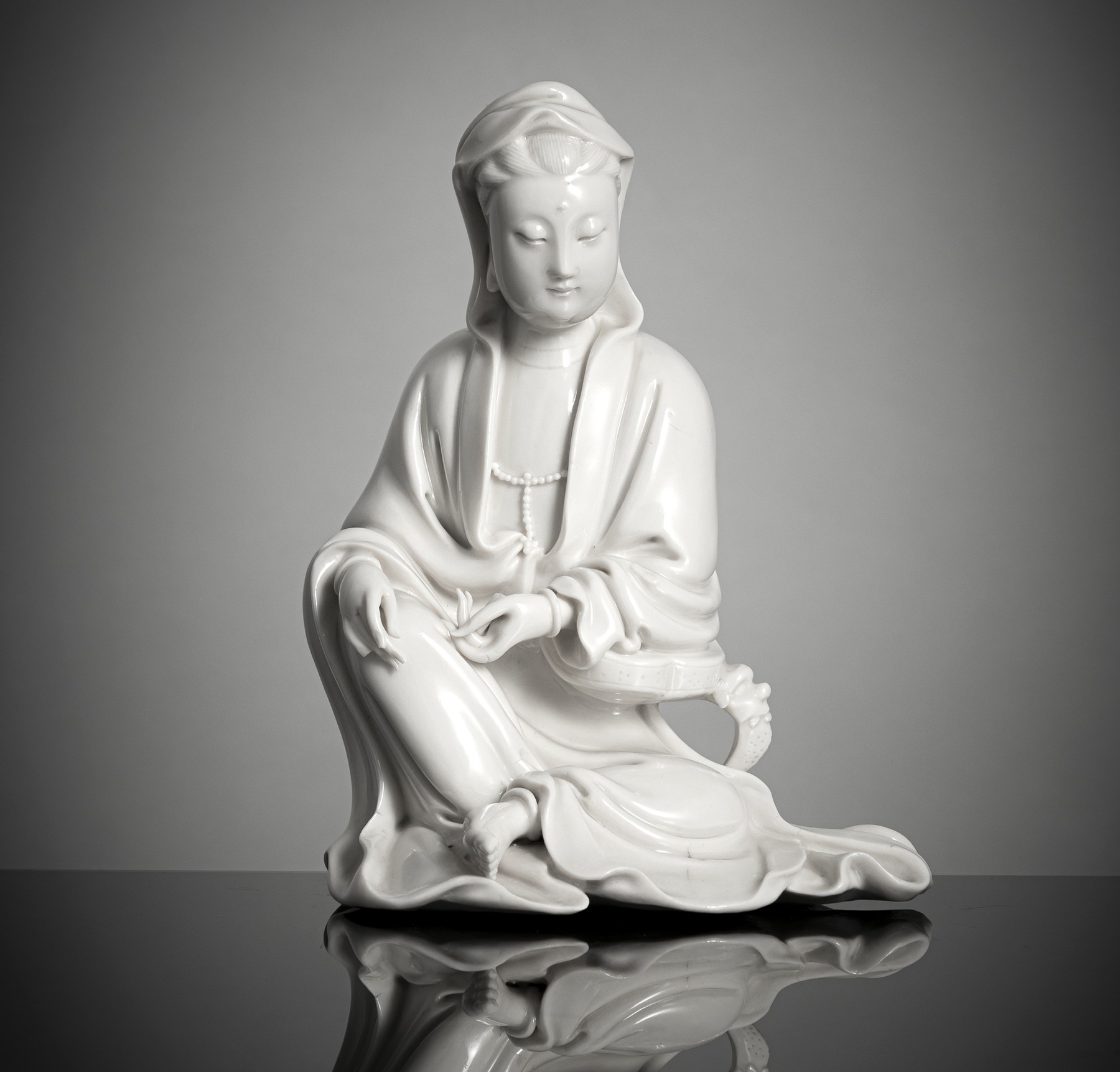 A delicate seated figure of Guanyin made of Dehua porcelainC... | bids